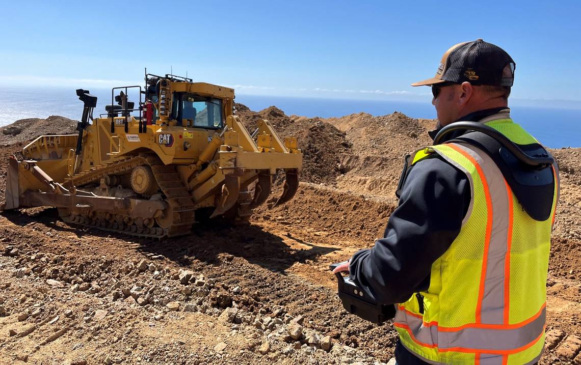 Remote-control bulldozers working on Highway 1 slide